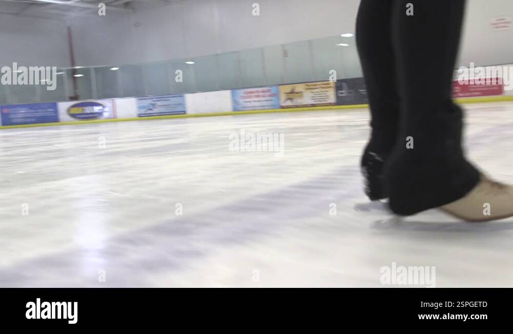 Female ice figure skating, closeup on feet, spinning, low angle, slow ...