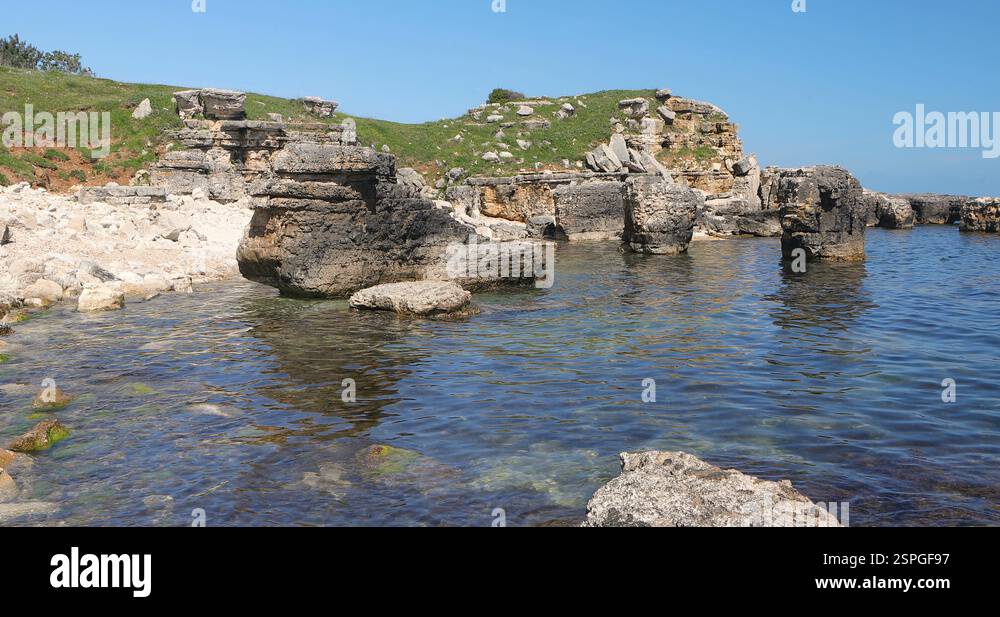 4K footage of jagged edge rocks and moss in the sea as an establishing ...