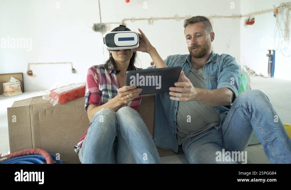 Couple with vr goggle and tablet watching virtual project on floor at ...