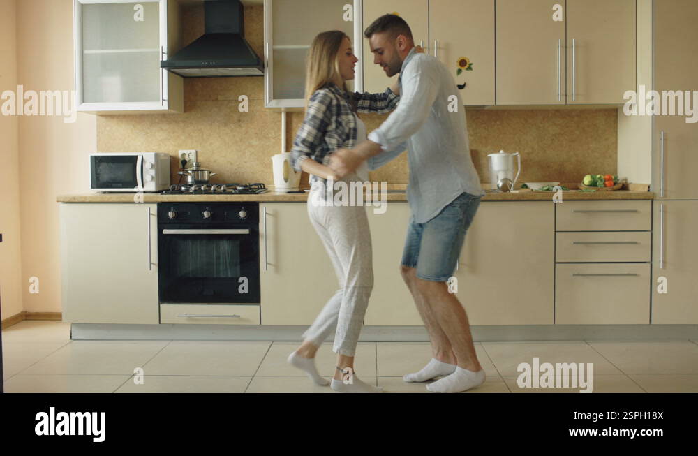 Attractive young joyful couple have fun dancing while cooking in the kitchen at Stock Video ...