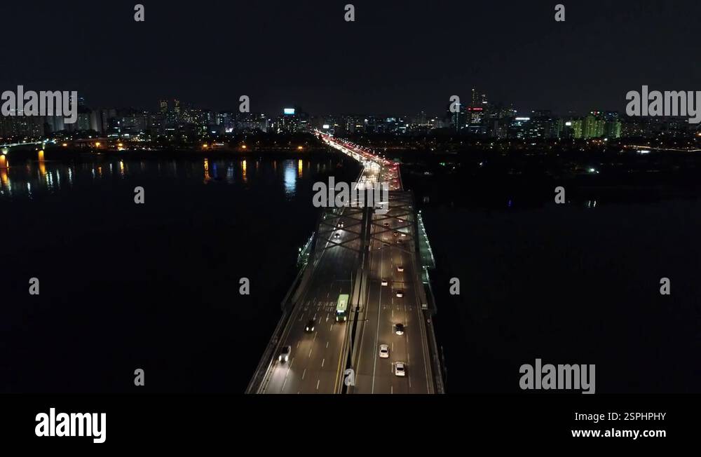 Slow push over a bridge and toward tall buildings at night in Seoul ...