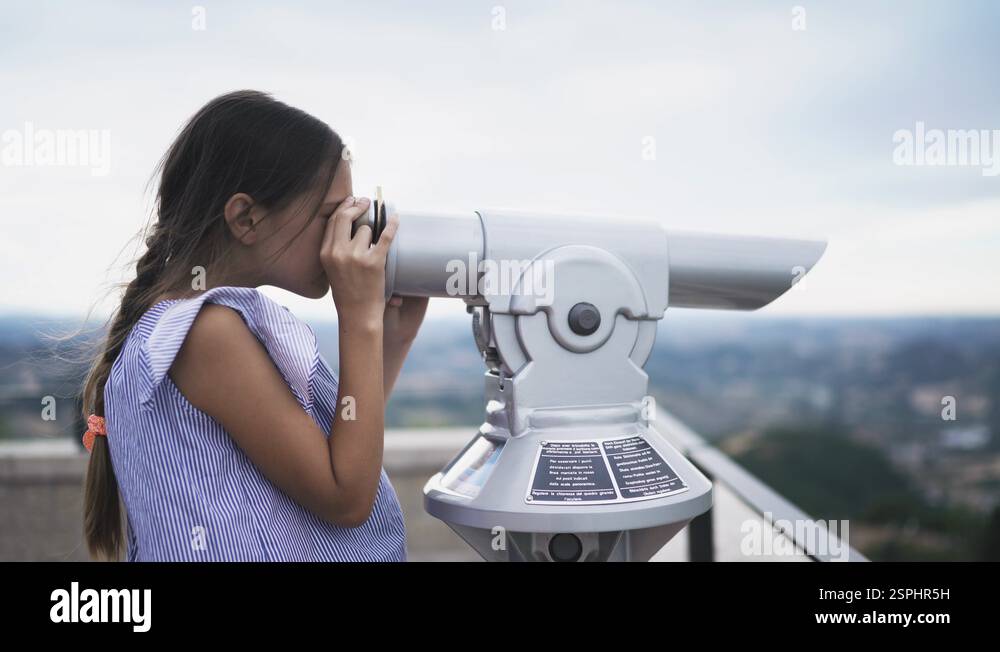 Little girl child looking through sightseeing binoculars on San Marino ...