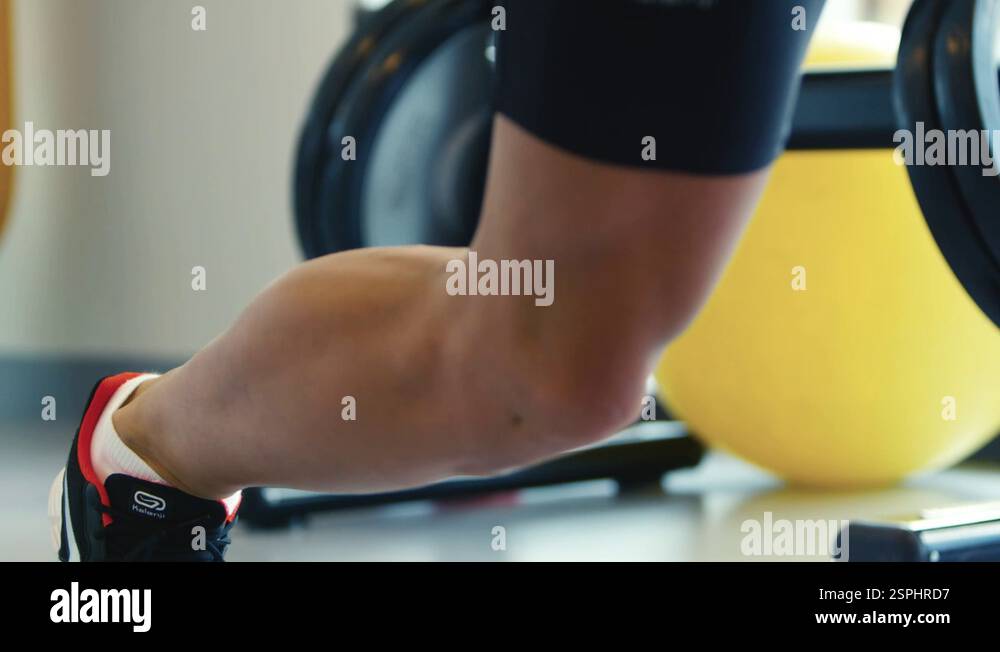 Slow motion of a man's legs during workout at the gym. Stepping board ...