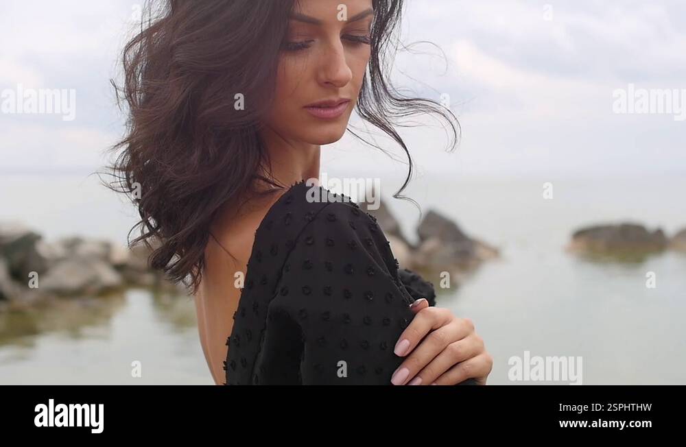 Close up portrait of beautiful young woman running hand through hair ...