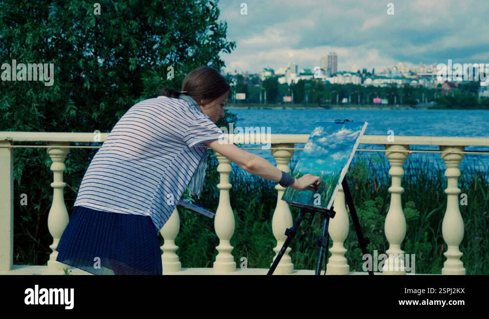 Good painter. A landscape female painter painting a picture with oil ...
