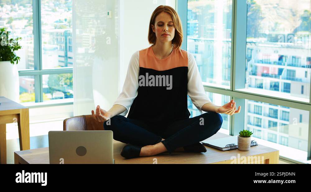Female executive meditating at her desk Stock Video Footage - Alamy