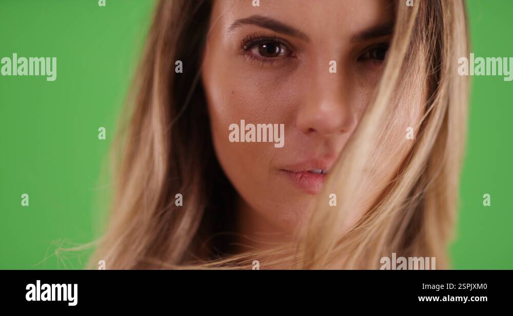 Closeup of attractive millennial girl staring at camera on green screen ...