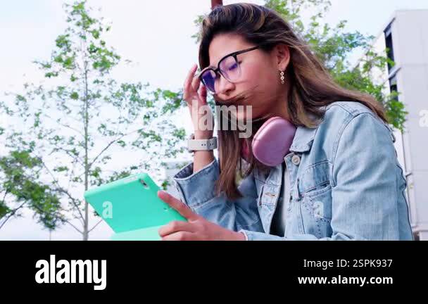 A young student on a university uses a tablet to study with an ...