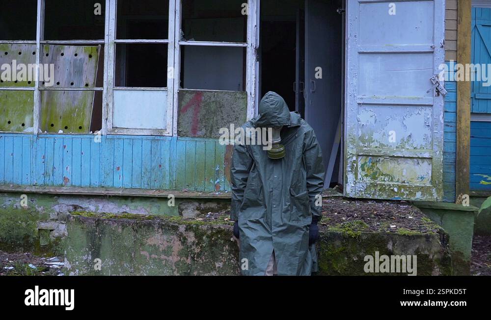 crazy stalker maniac in a gas mask guarding the entrance with an ax ...