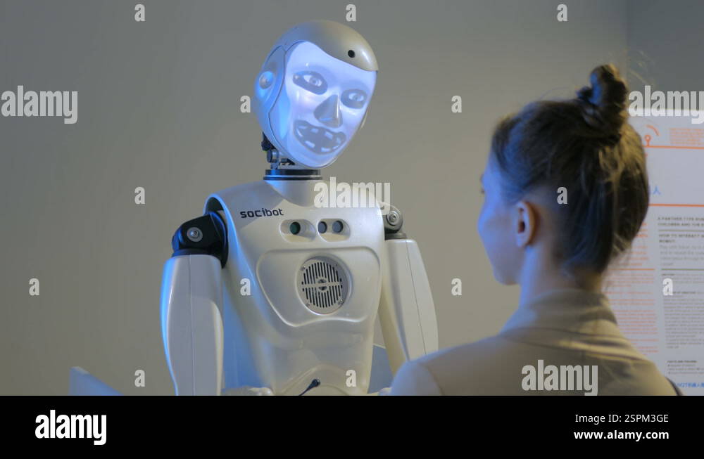 Funny humanoid robot with display face talking with woman, technology ...