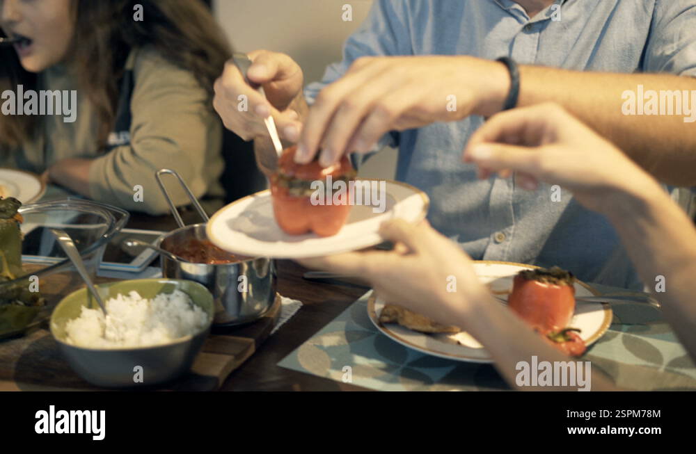 Husband serving food on his wife plate during dinner at home Stock ...