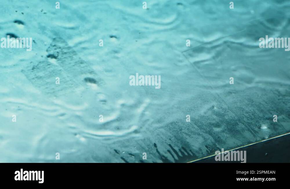 Rain and hailstones falling over a car body. Slow motion detail shot ...