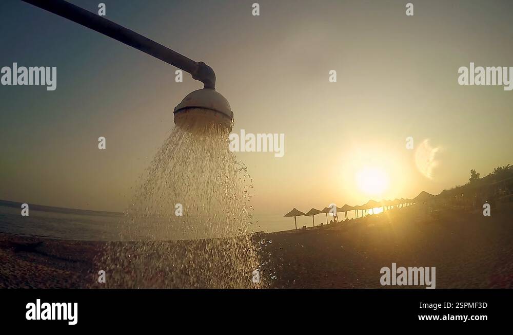 Summer beach shower water pouring down against sunset sun, SLOW MOTION ...