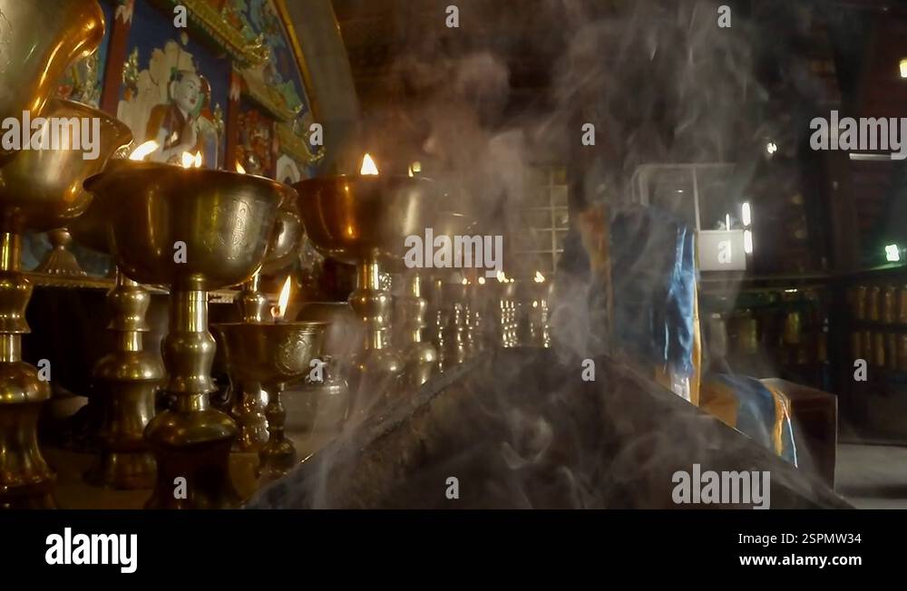 smoke on a buddhist altar close-up, lights and statues in a temple in ...
