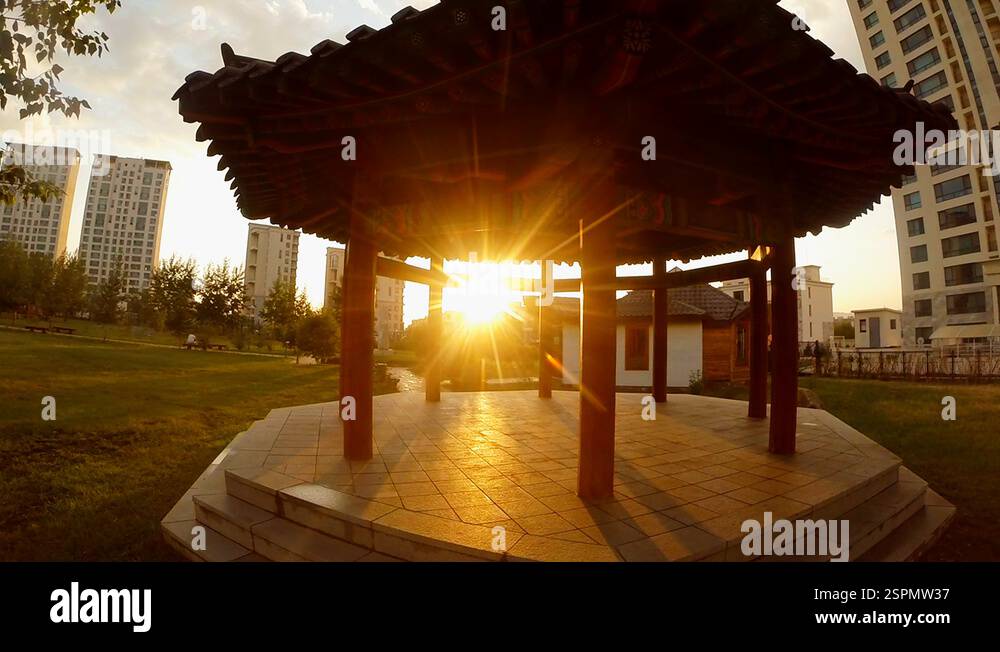 Sunlight shines through an ancient wooden building next to modern ...