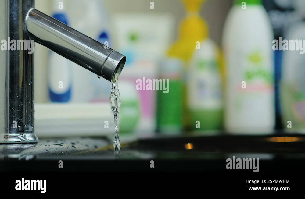 Stream of water flowing and stops flowing from an aluminum tap in the ...