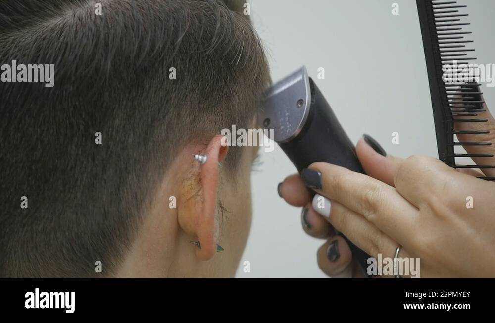 Haircut at barber's. Female hairdresser shaping women's hair into a ...