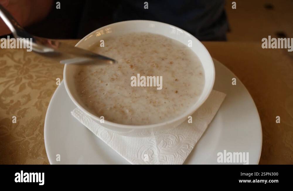 someone is eating hot oatmeal for breakfast in a cold cafe. 4k, slow ...