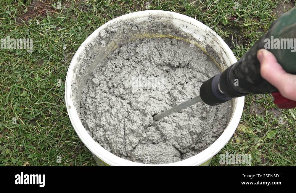 Builder mixing plaster in a bucket using an electric mixer Stock Video ...