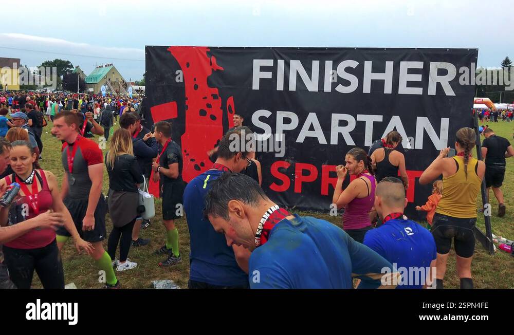 Participants after the Spartan Race - a logo tarp in the background ...