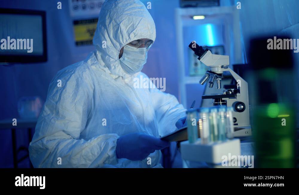 Virologist using a pipette to place a sample under a microscope 4k ...