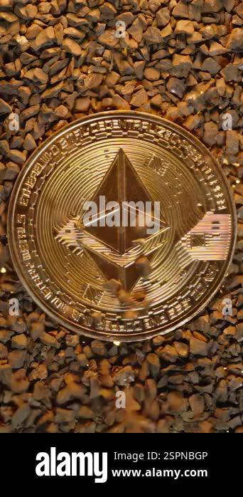 Vertical video. Golden Ethereum Coin Partially Buried Under Falling ...