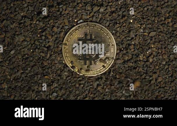 Close-Up of a Gold Bitcoin Partially Covered by Gravel as Rocks Fall in ...