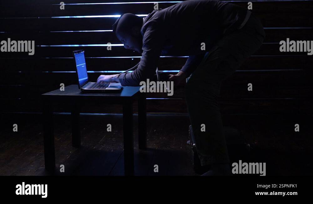 comic funny hacker commits a cyber attack with a laptop and a gun in ...