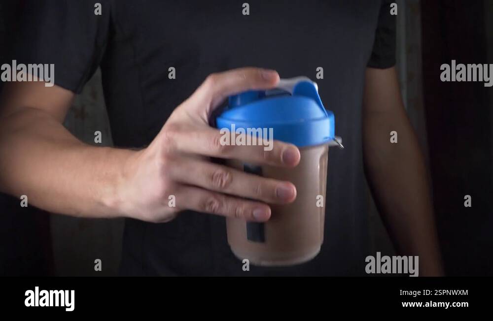 Slow motion. 4k. Young man making a protein shake at home. anonymously ...