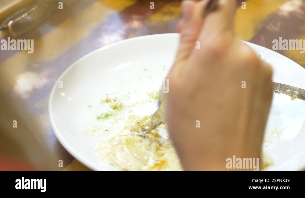 a woman at a restaurant eating a chicken roll with potatoes. 4k Stock ...