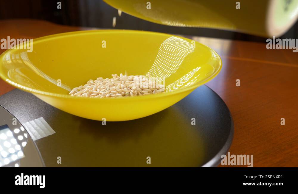 someone measures a piece of brown rice, on an electronic scale in the ...