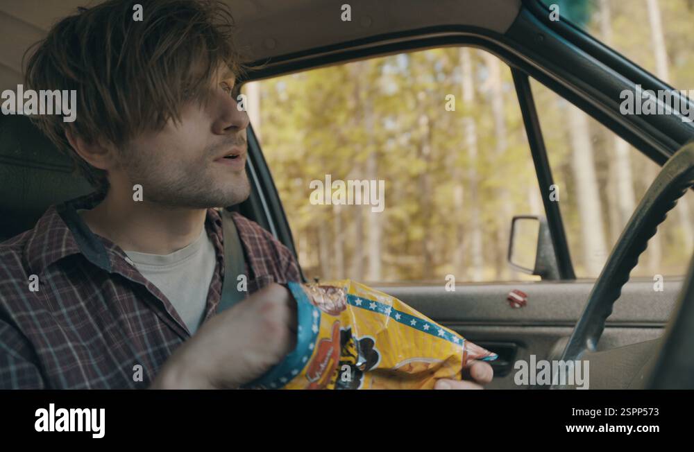 Man eating cheese balls while carelessly driving and crashes Stock ...