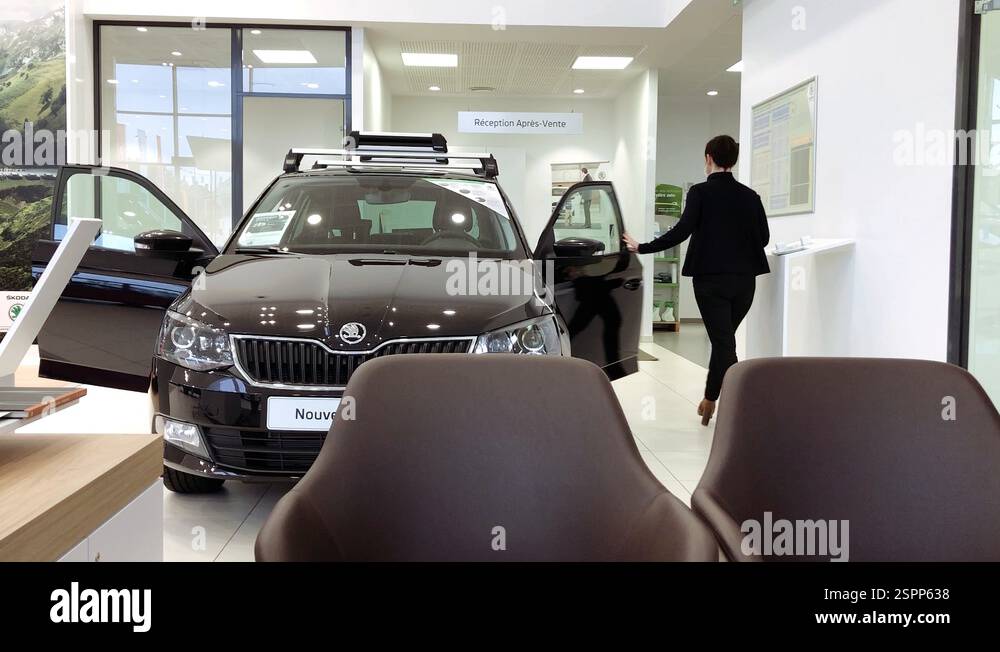 Female manager inside car dealership closing door of new car Stock ...