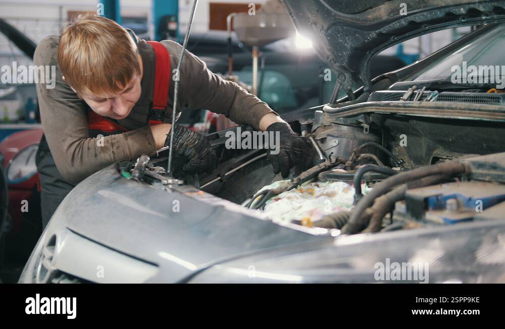 Mechanic checks automobile engine, car repair, working in the workshop ...