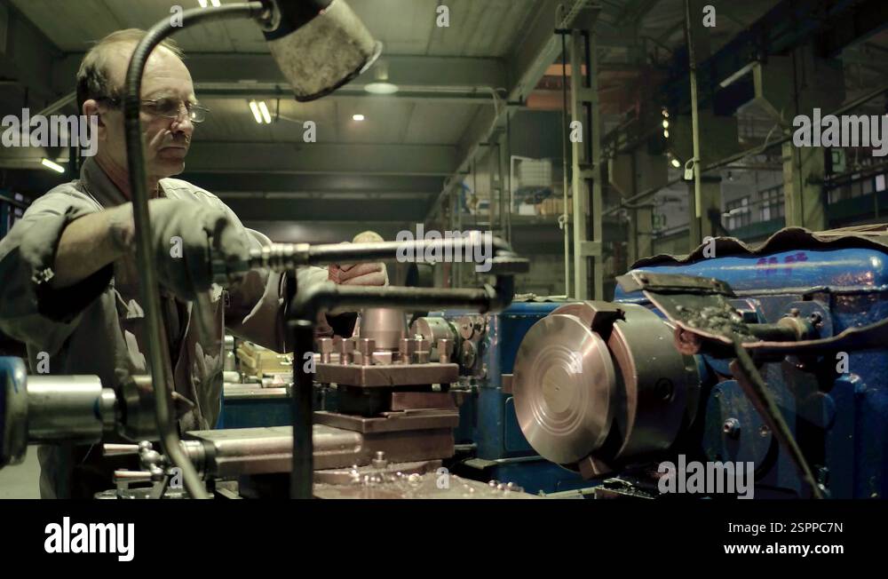 Factory employee using professional equipment for metal working detail ...