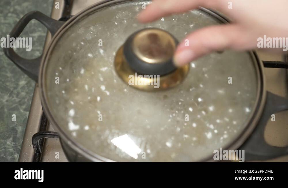 Preparation of brown rice. Boiling water with cereal in a saucepan on ...
