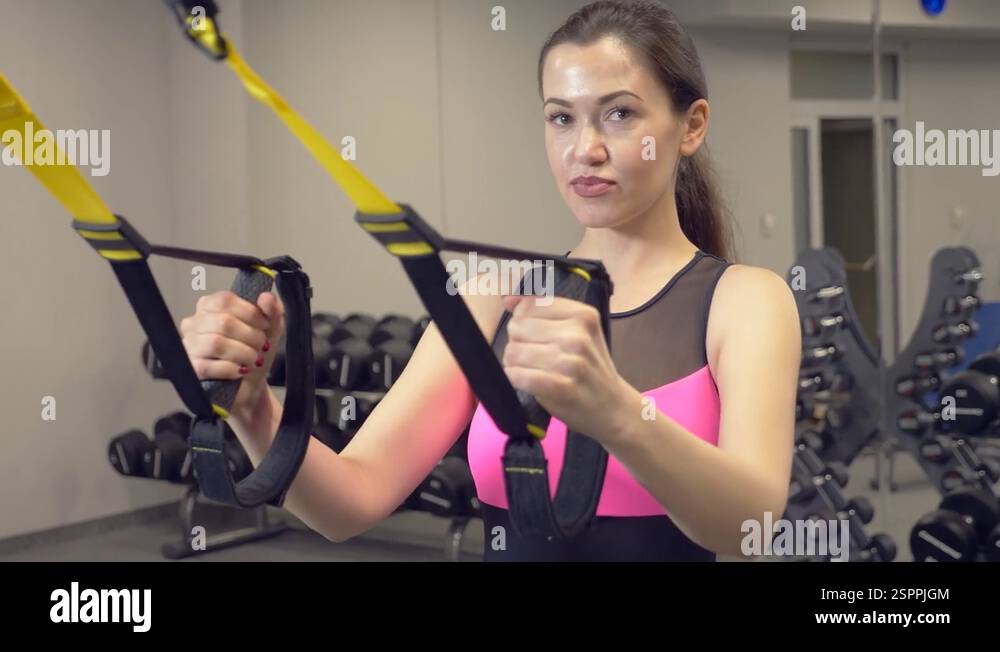 Young adult girl doing a workout on the simulators led by her personal ...