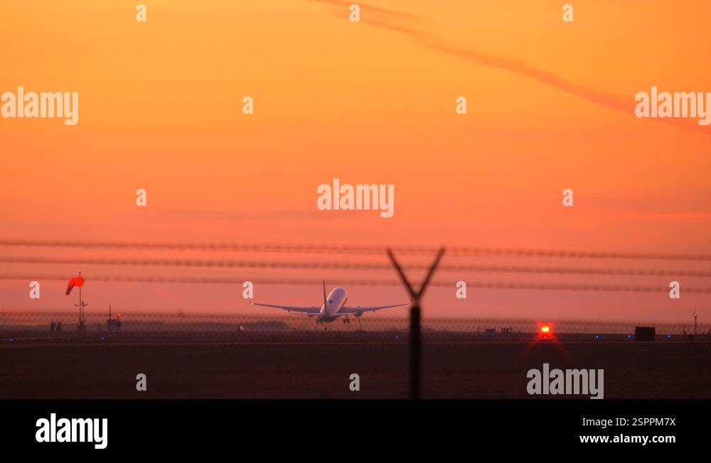 Twin engine jet airliner taking off at LAX against an orange sky sunset Stock Video Footage - Alamy