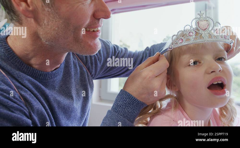 Father placing tiara over daughters head 4k Stock Video Footage - Alamy