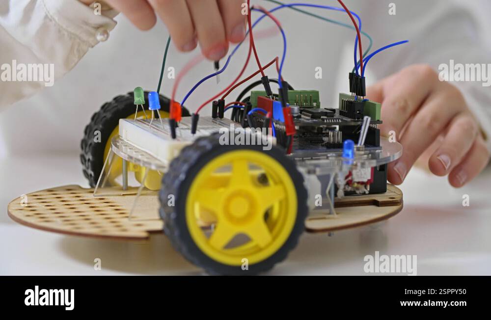 Girl teenager constructing model bot car with multicolored backlight ...