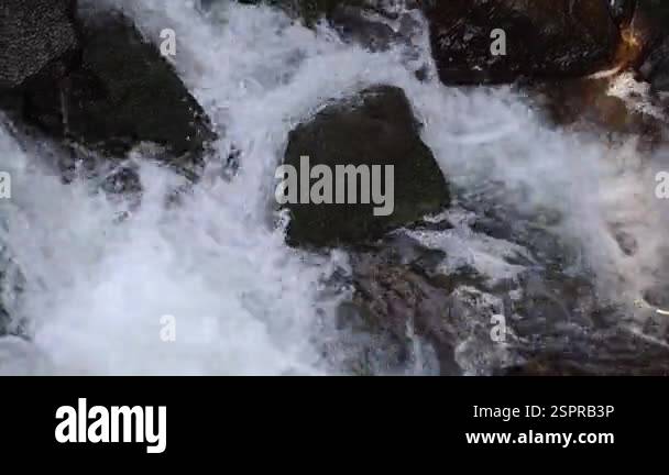 A powerful river surging with intensity, creating white foam as it ...
