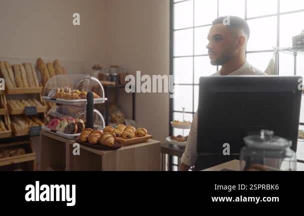 Two men interacting in a bakery shop with various pastries displayed on ...