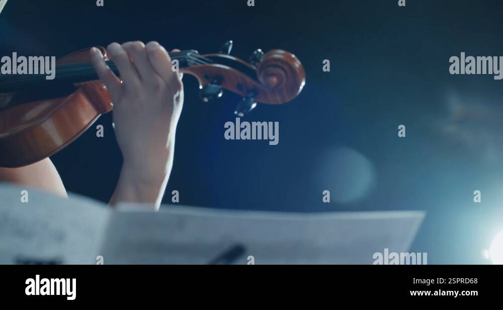 detail shot, performance of violinist girl on stage, light, dark ...