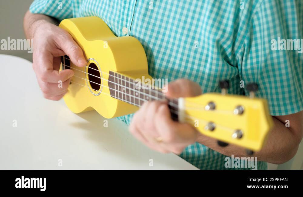 A man plays on a ukulele of yellow color Stock Video Footage - Alamy