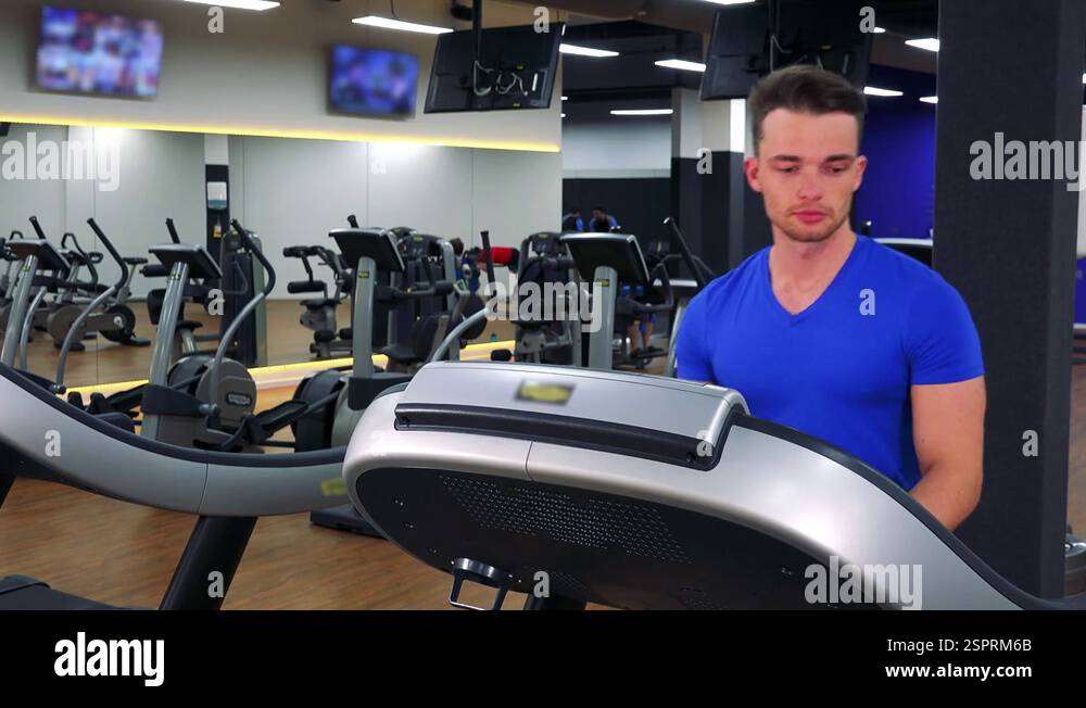 A young fit man walks on a treadmill in a gym - closeup Stock Video ...