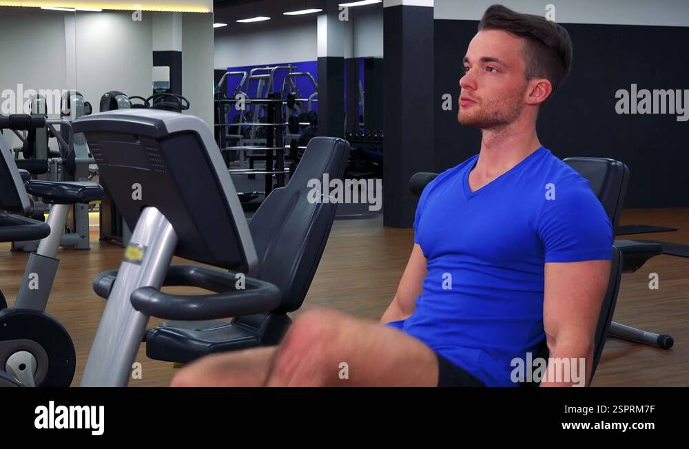A young fit man trains on a recumbent bike in a gym - closeup Stock ...