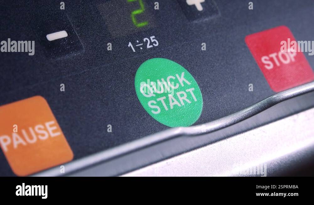 A man presses a "Quick Start" button on a screen of an exercise bike in ...