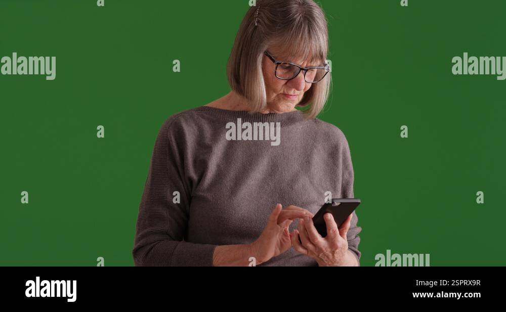 Somber lady reading e-mail on cell phone indoors green screen studio ...