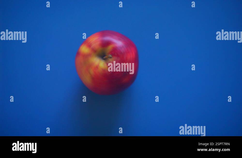 Delicious ripe red apple rotating against a blue background.Top view ...