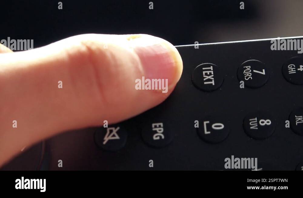 A woman turns a TV volume up and down with a remote control - closeup ...